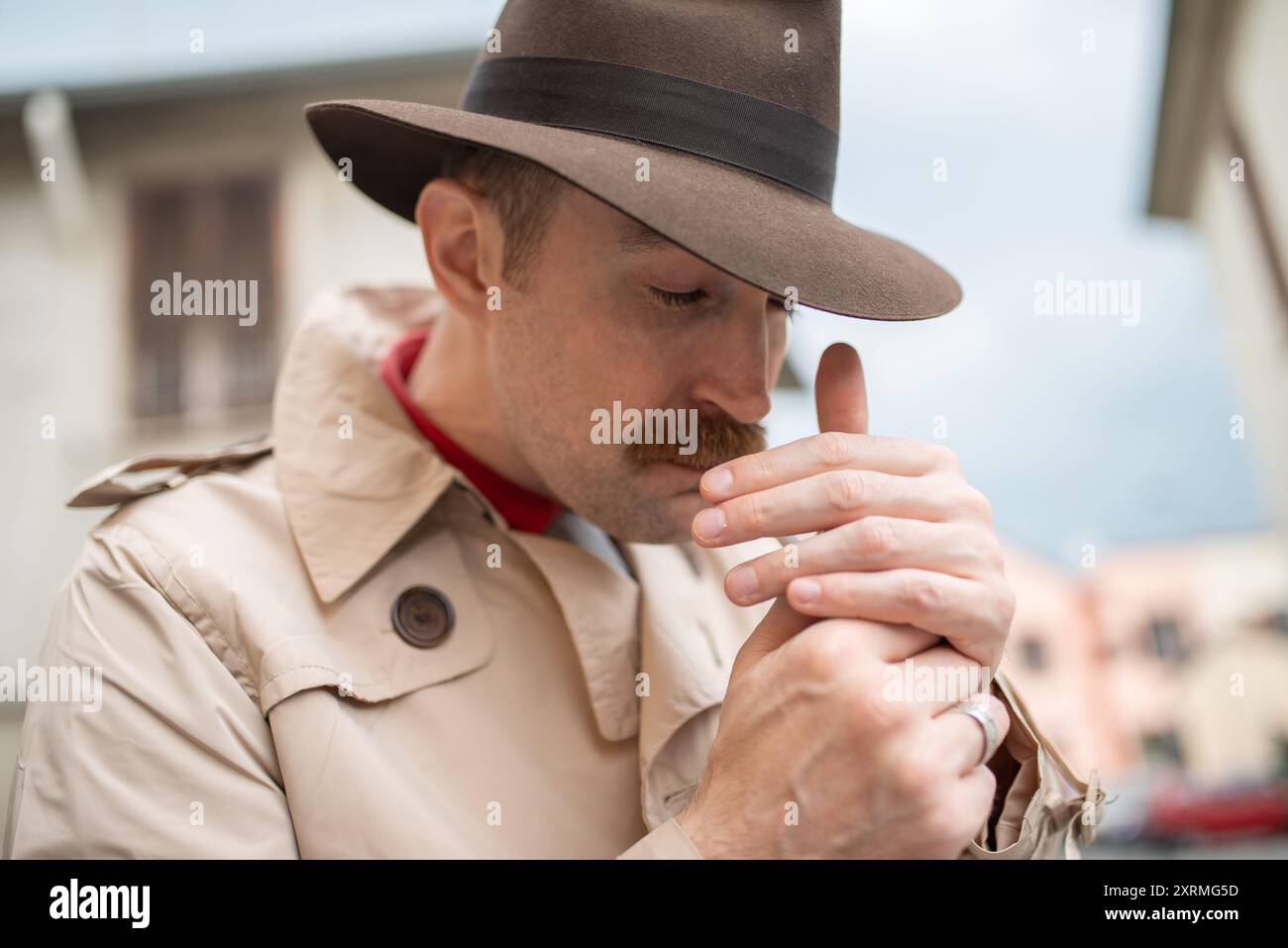 Detective lighting a cigarette while waiting in front of his vintage ...