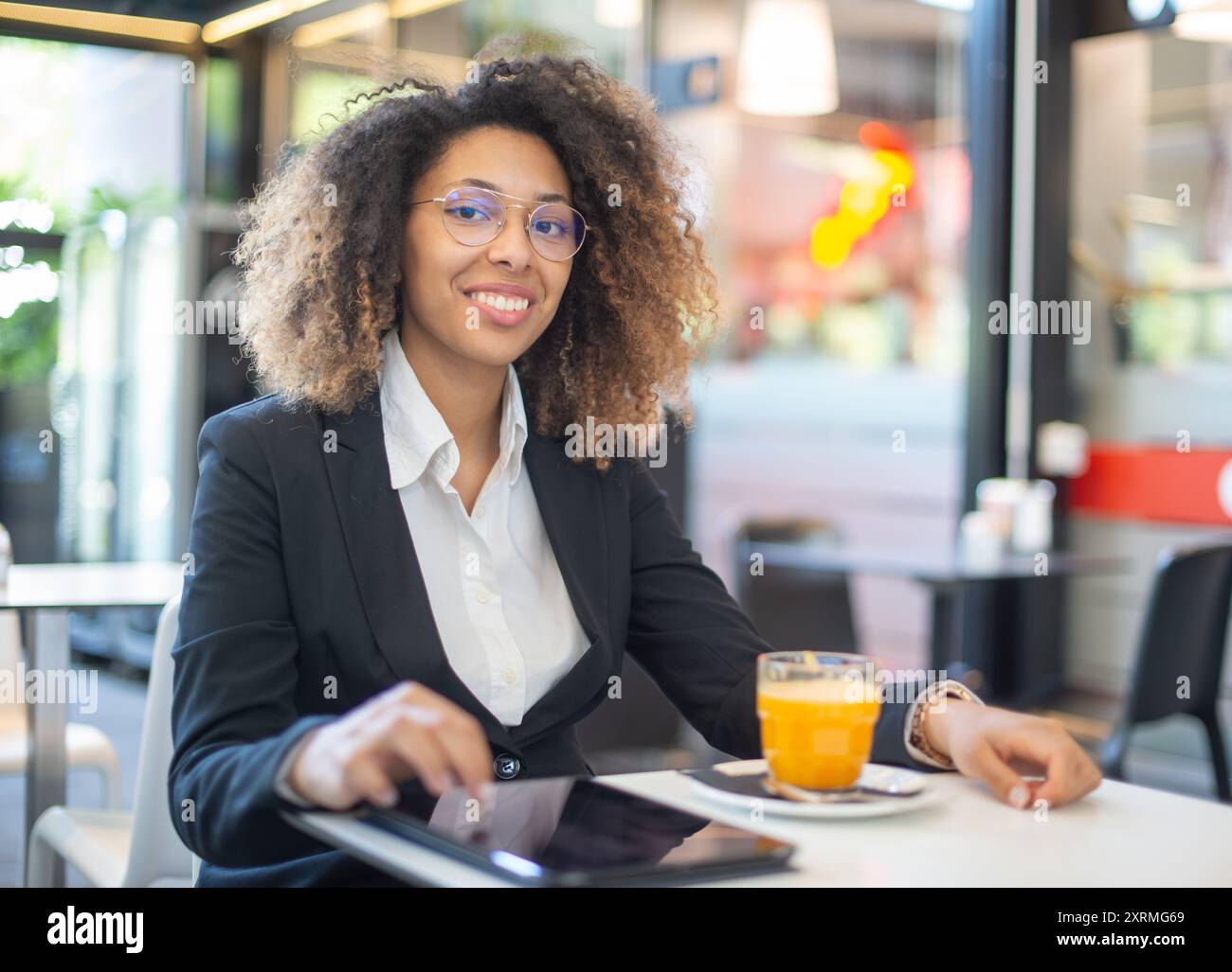Black woman drinking an orange juice Stock Photo - Alamy