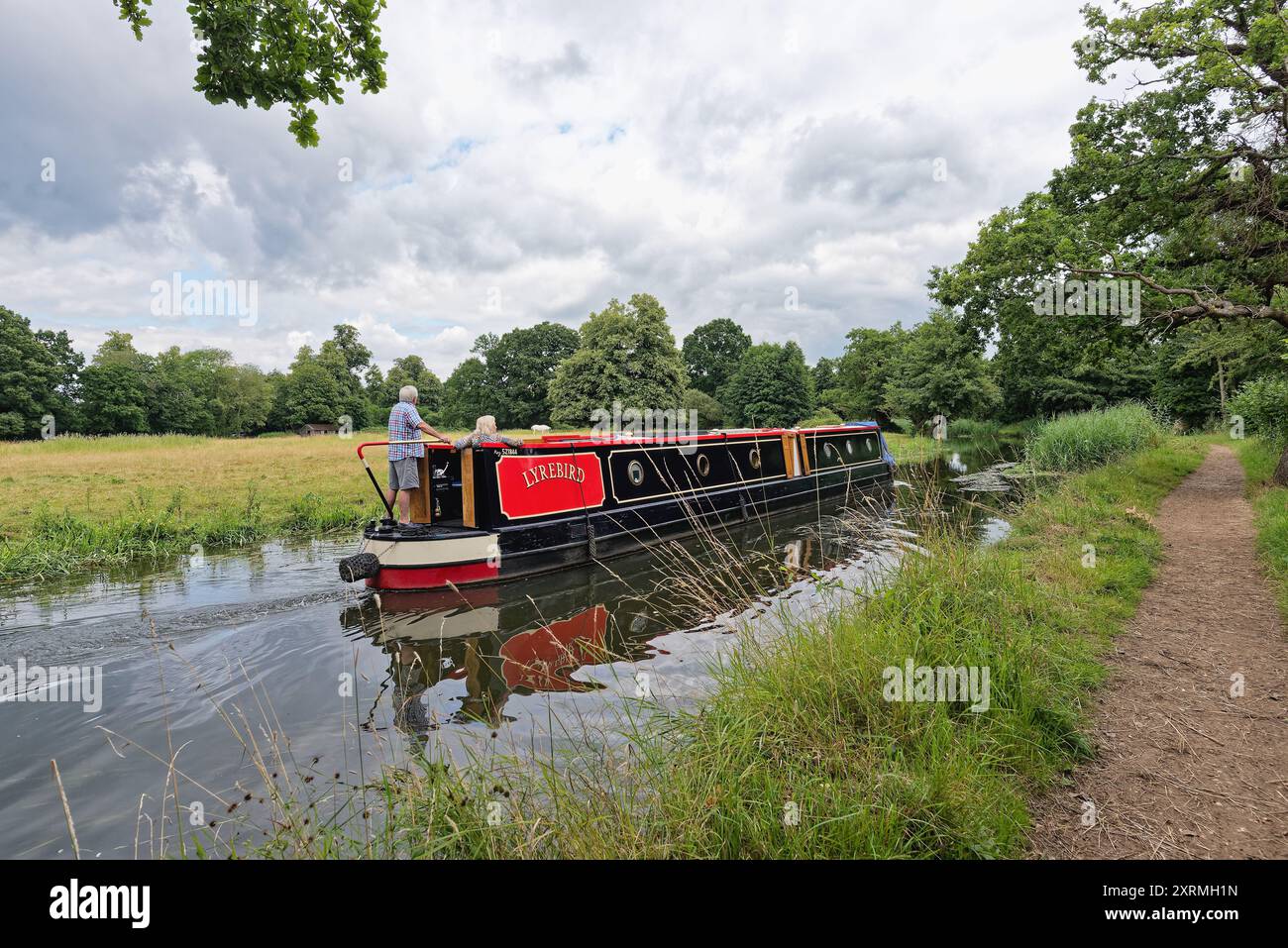 A narrow boat cruising on the River Wey navigation canal near Byfleet ...