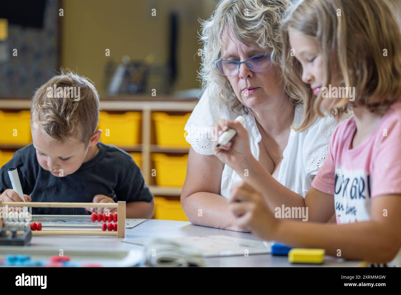 A teacher is helping a child with a math problem. The teacher is ...