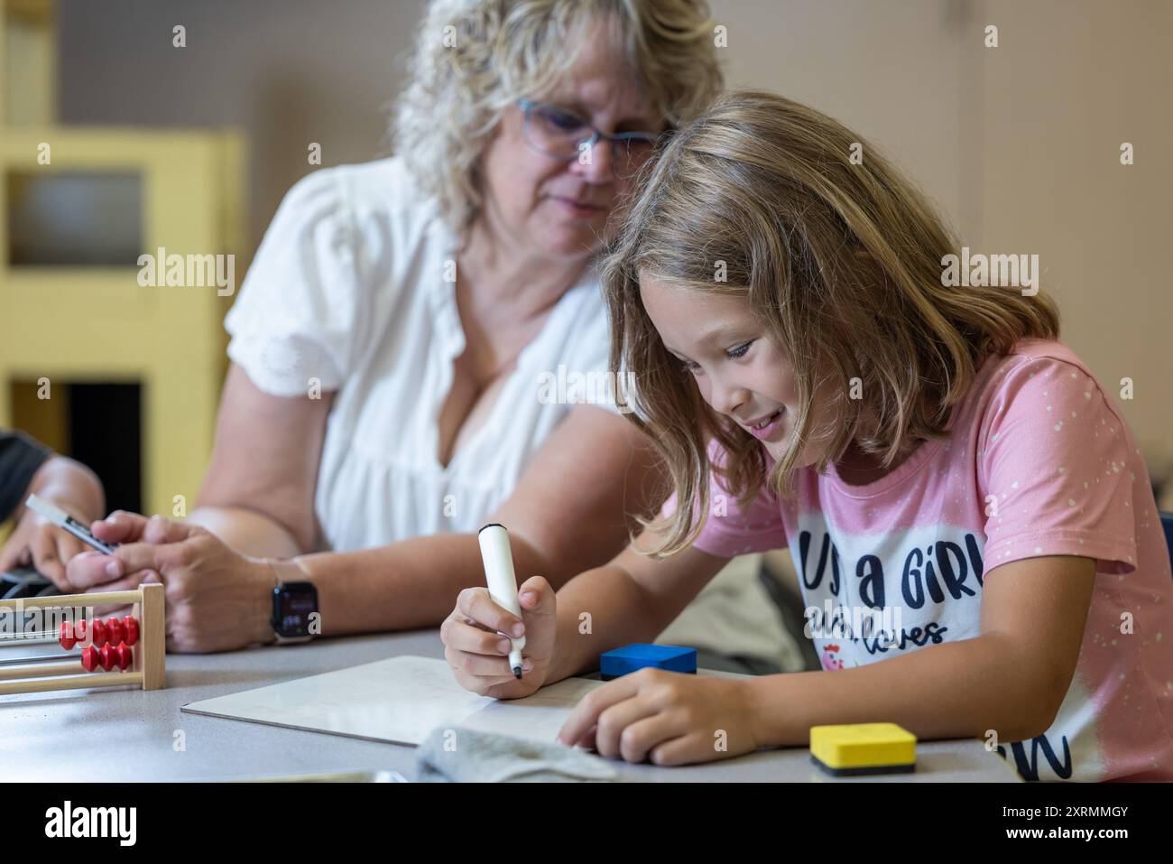 A teacher is helping a child with a math problem. The teacher is ...