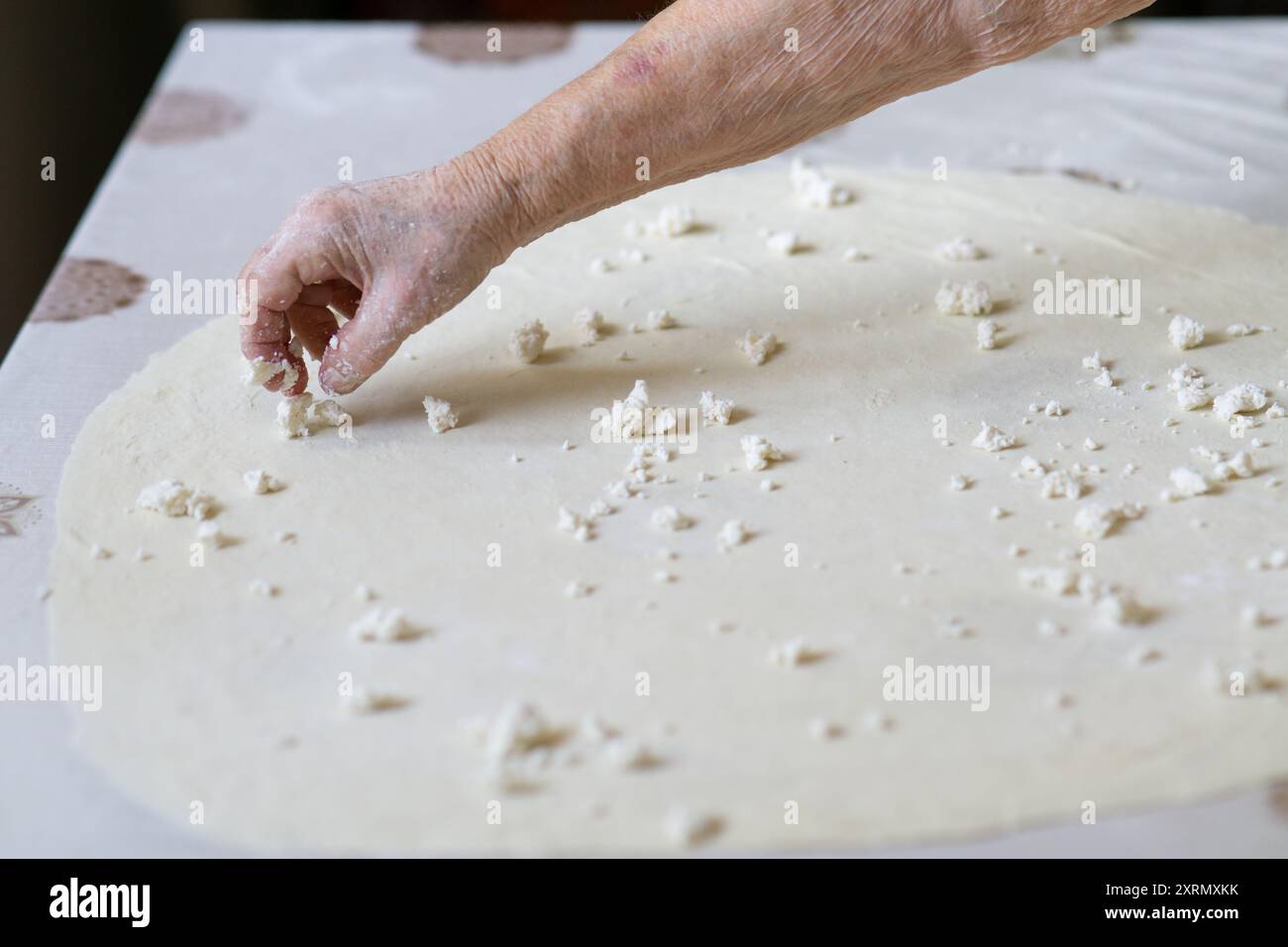 Old woman hands putting cheese on a rolled dough Stock Photo - Alamy