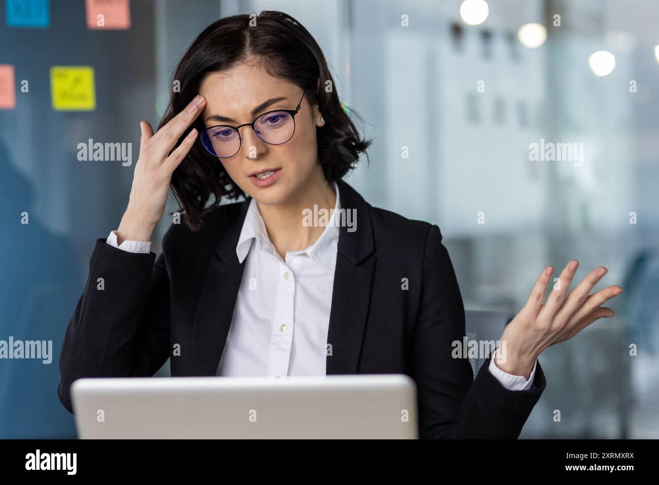 Businesswoman looking frustrated while reading bad news on laptop in ...