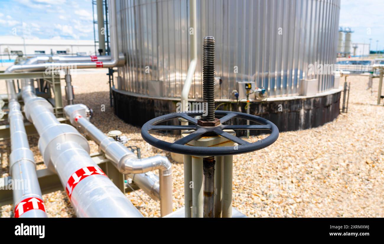 Handle of a manual vertical crane on a pipe coming out of a large tank ...