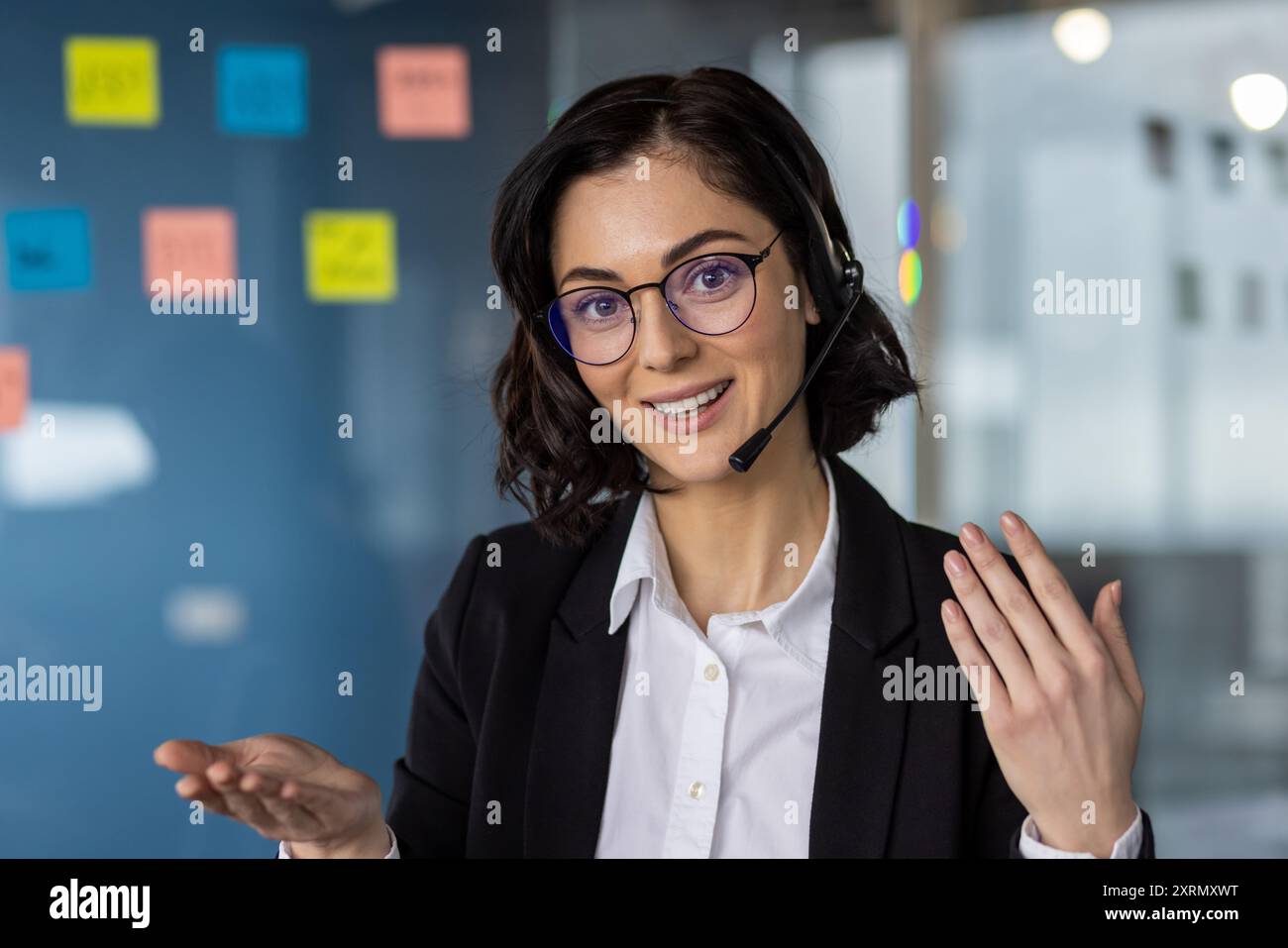 Businesswoman with glasses and headset engaging in video call ...