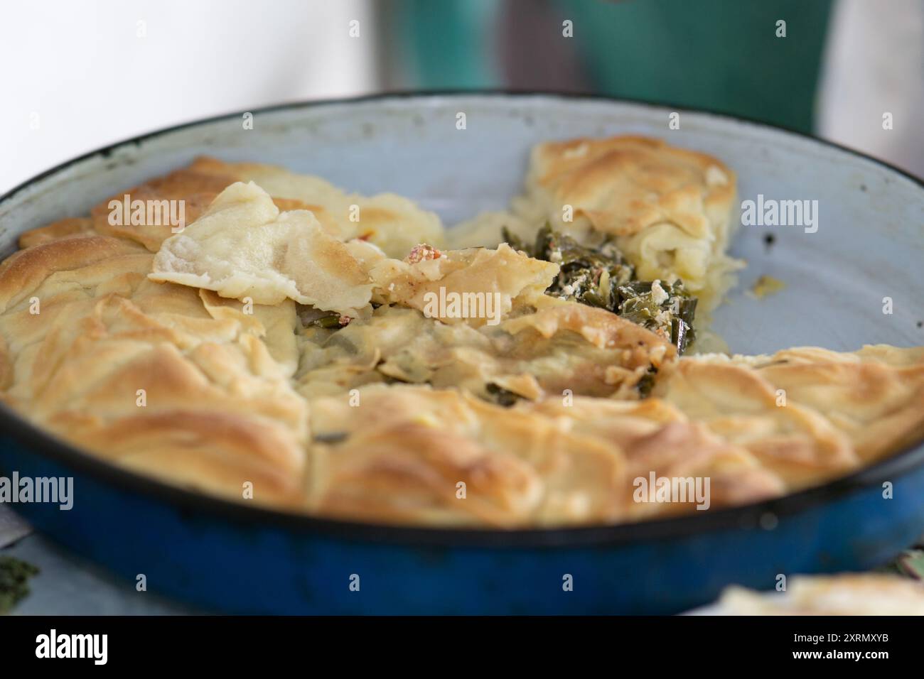 Half eaten baked traditional balkan pie in a pan with filling in the ...