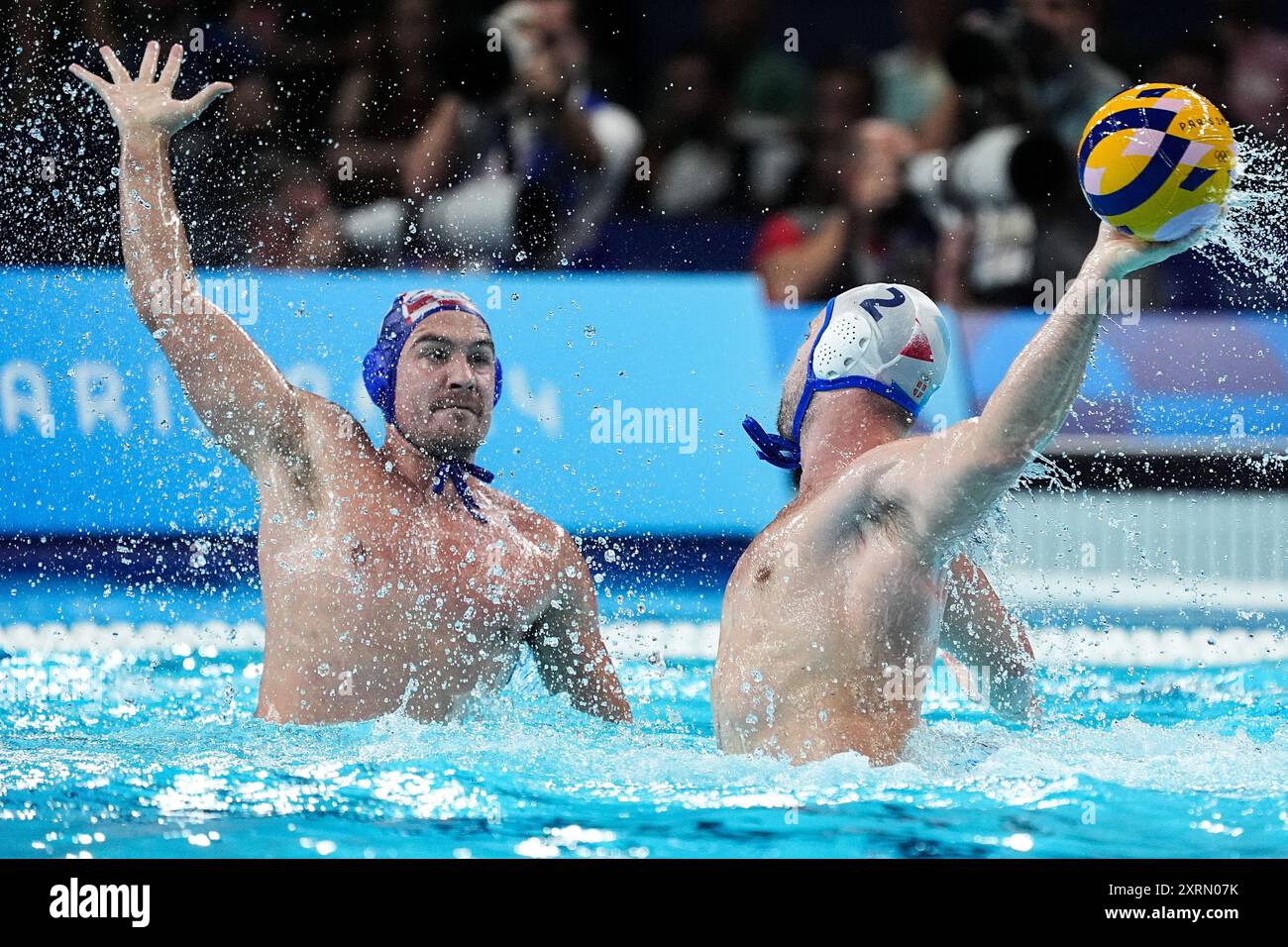 Paris, France. 11th Aug, 2024. Dusan Mandic (R) of Serbia attacks during the water polo men's ...