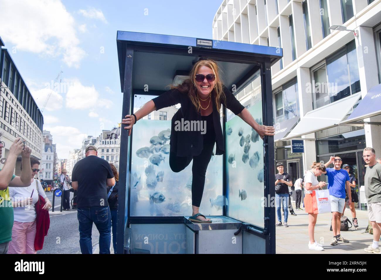 A woman poses for a photo inside the police sentry box in the City of ...