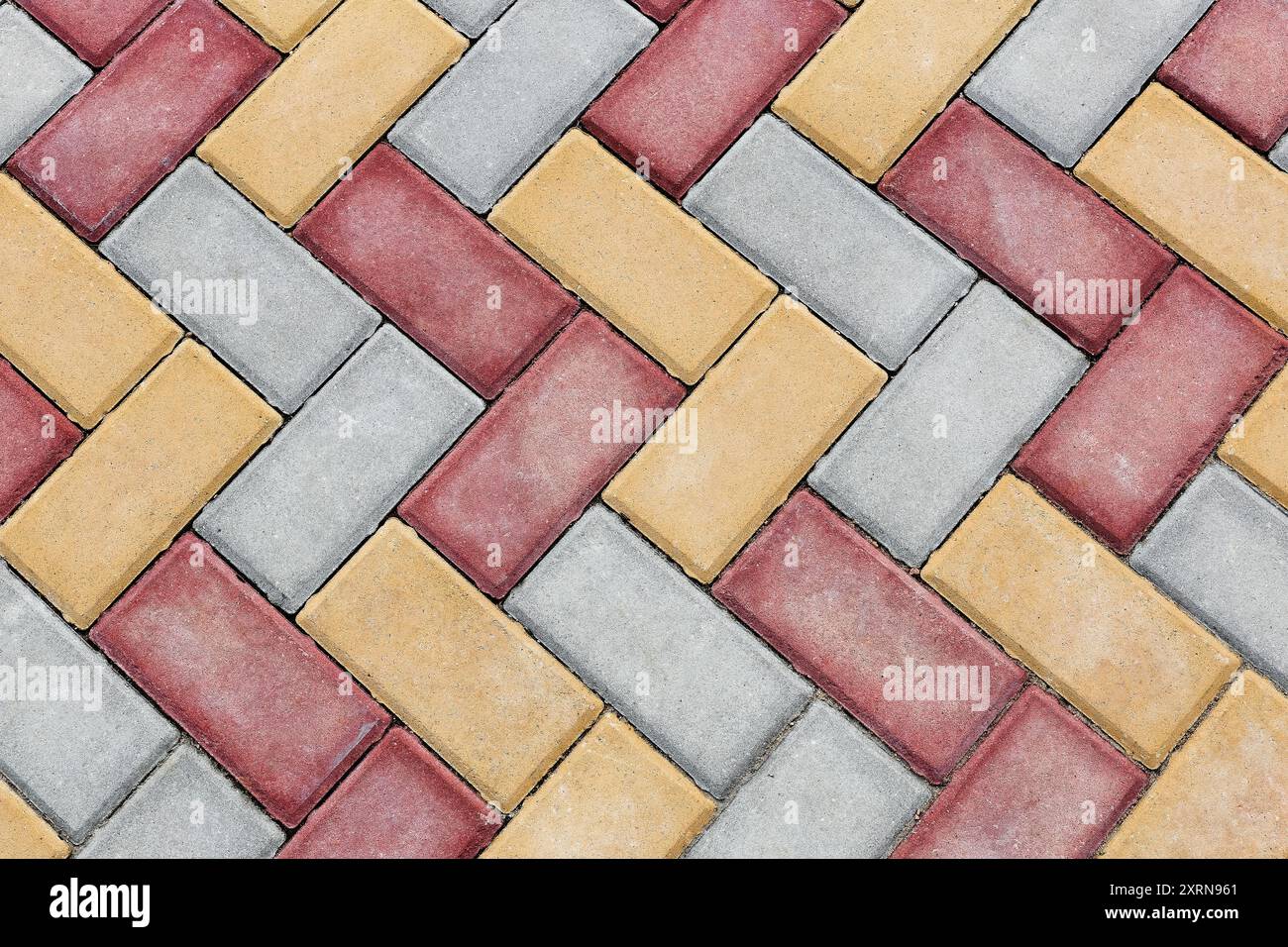 Red and yellow Brick paving stones on a sidewalk or pavement. Top view ...