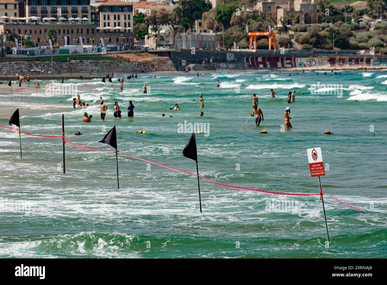 Charles Clore beach with black flags in Tel Aviv. People swim despite ...
