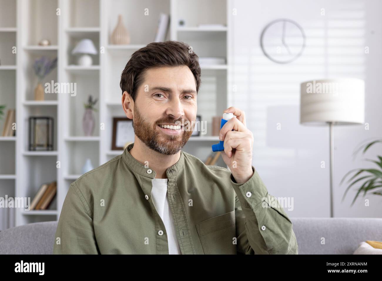 Man Using Inhaler For Asthma Relief Sitting At Home Smiling Person Demonstrating Proper Use Of