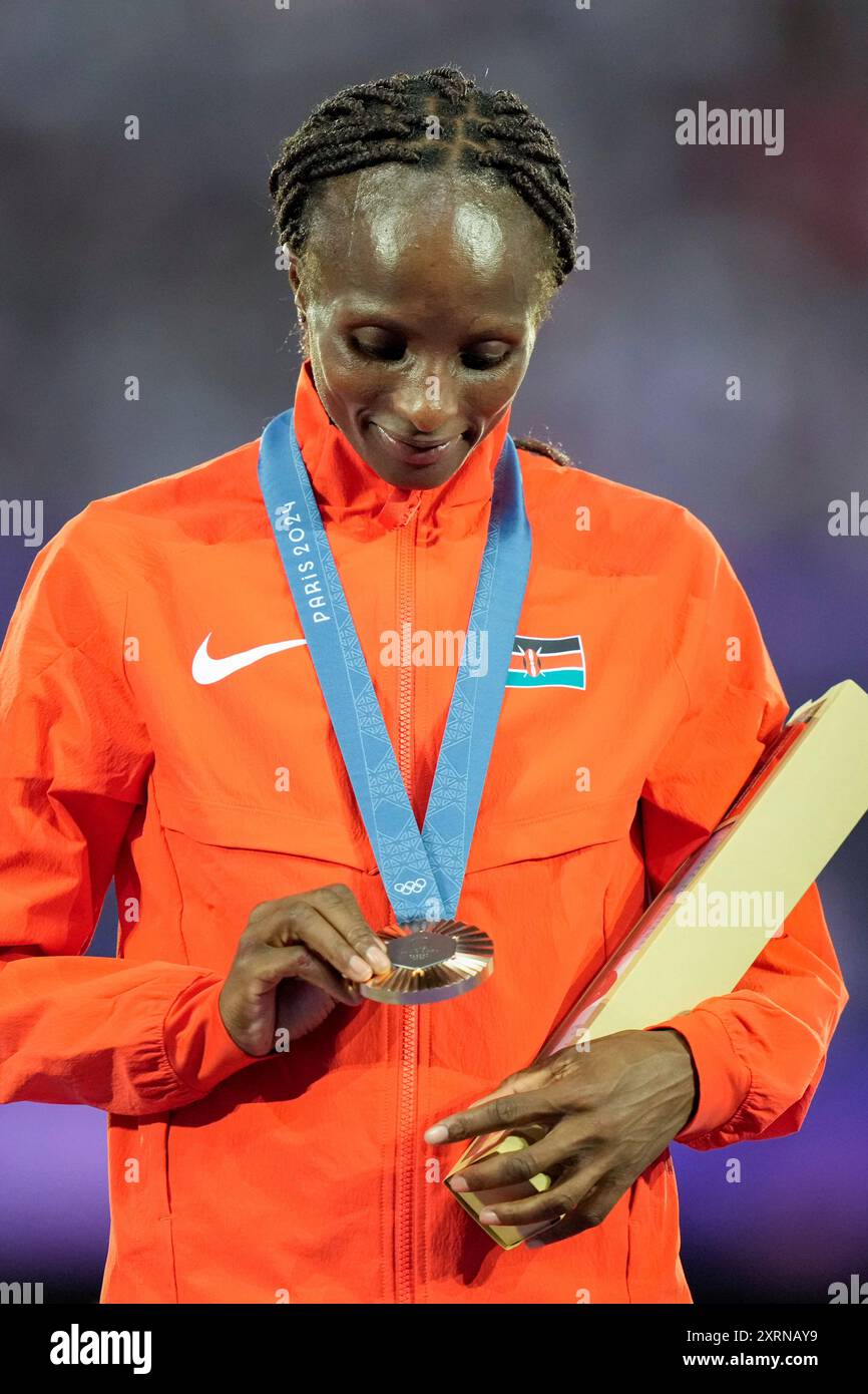 Hellen Obiri, of Kenya, looks at her bronze medal on the podium for the ...