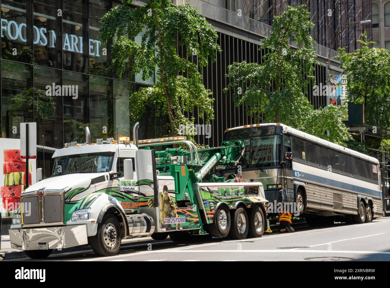An inoperative bus is attached to a tow truck on Madison Avenue in ...