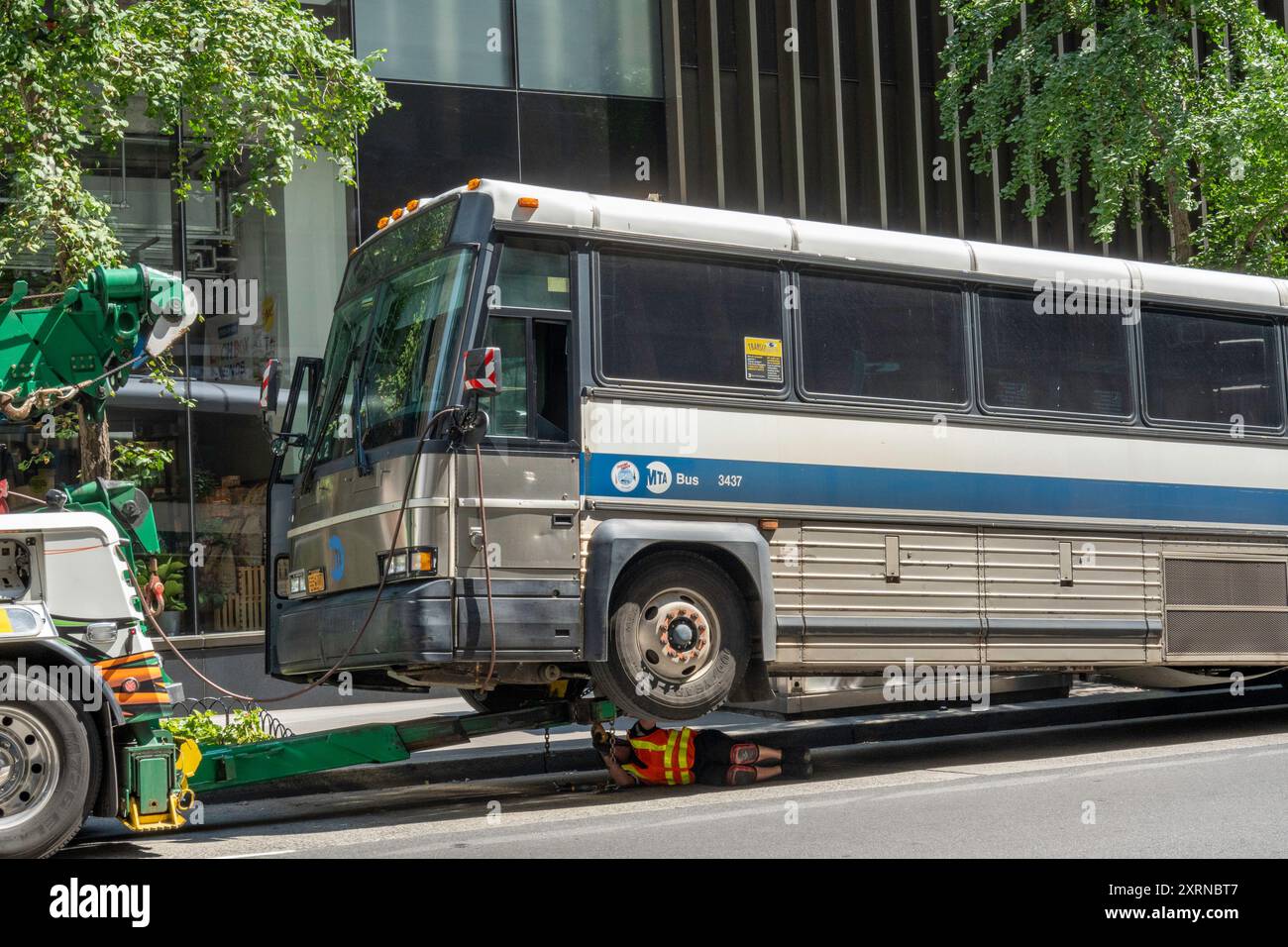 An inoperative bus is attached to a tow truck on Madison Avenue in ...