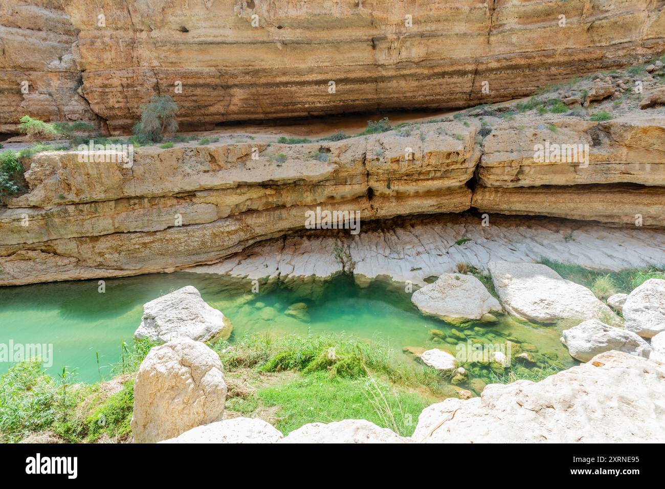 Green lake waters in the middle of Wadi Shab canyon rocks, Tiwi ...