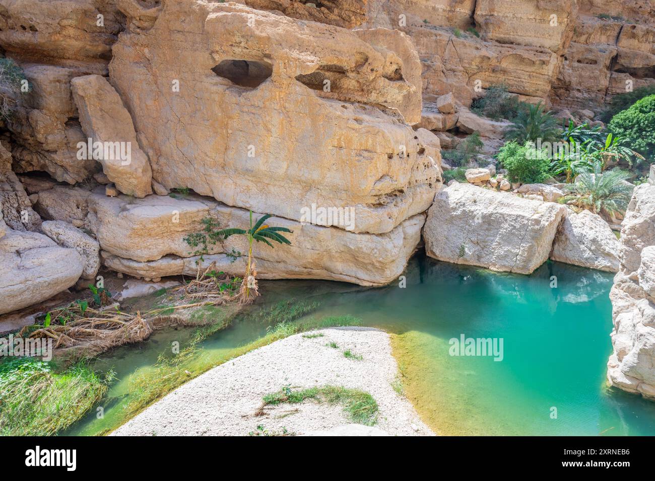 Green lake waters in the middle of Wadi Shab canyon rocks, Tiwi ...