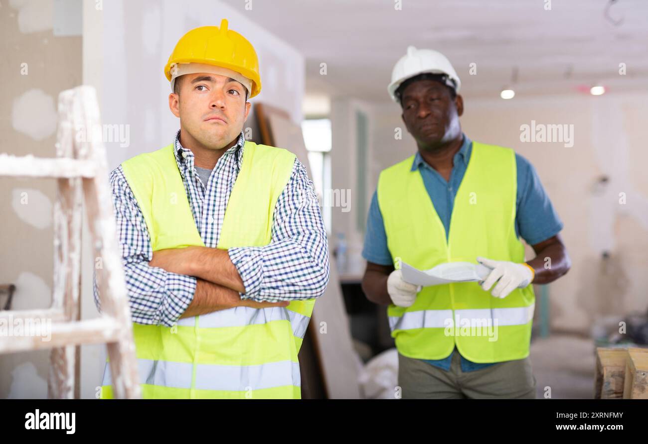 Portrait of confused man builder and his employer Stock Photo - Alamy