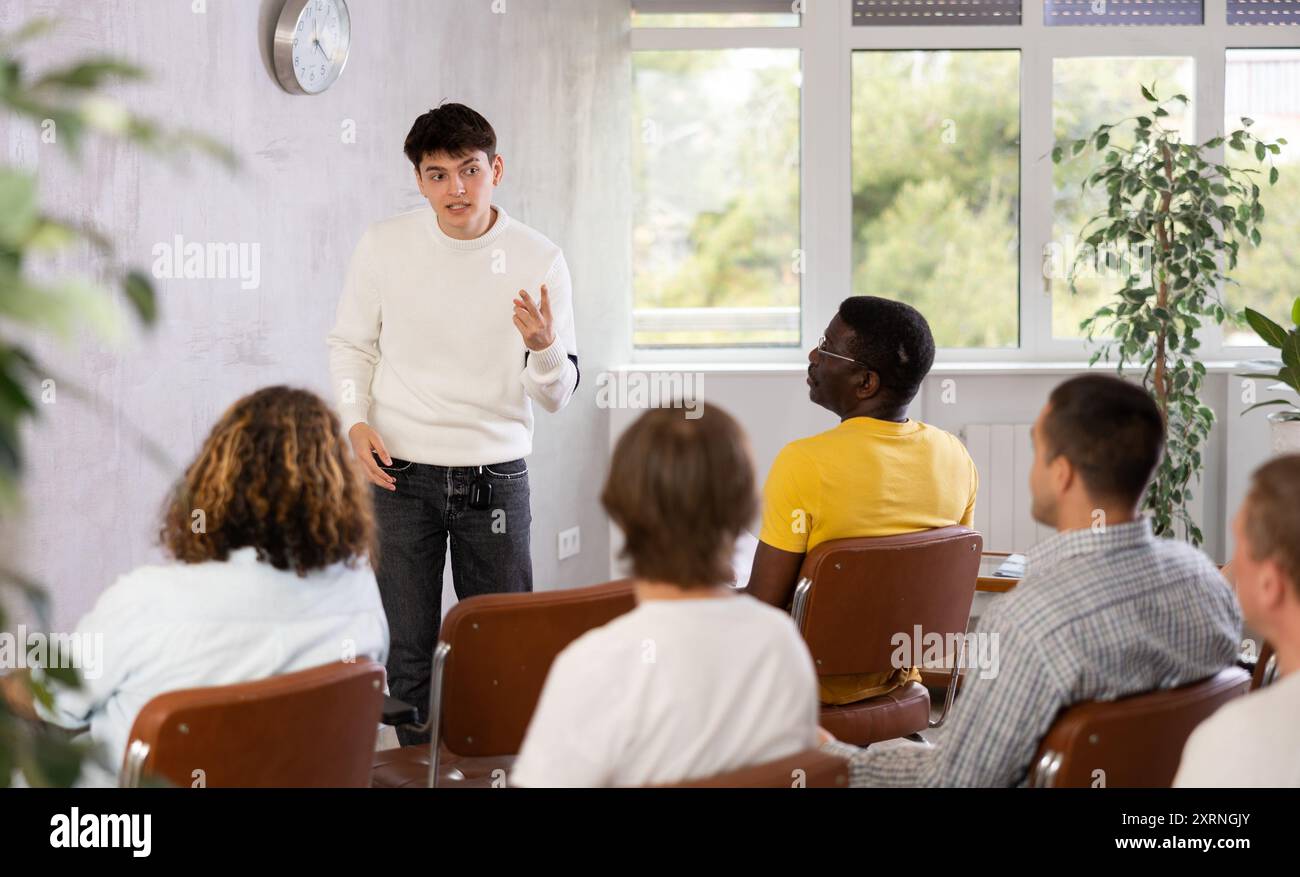 Guy giving lecture to group of men during educational class Stock Photo ...