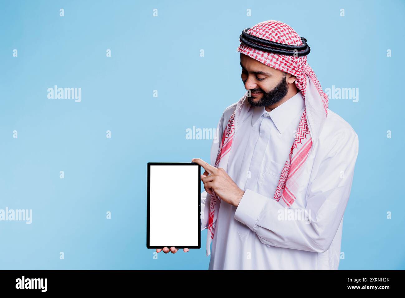 Man wearing traditional muslim clothes presenting digital tablet white ...