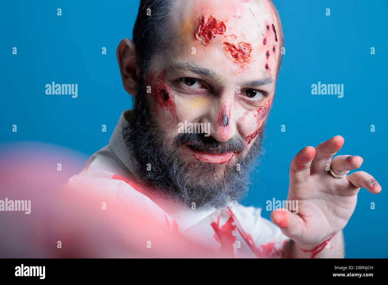 Man dressed as zombie for Halloween event turning hand into claw ...