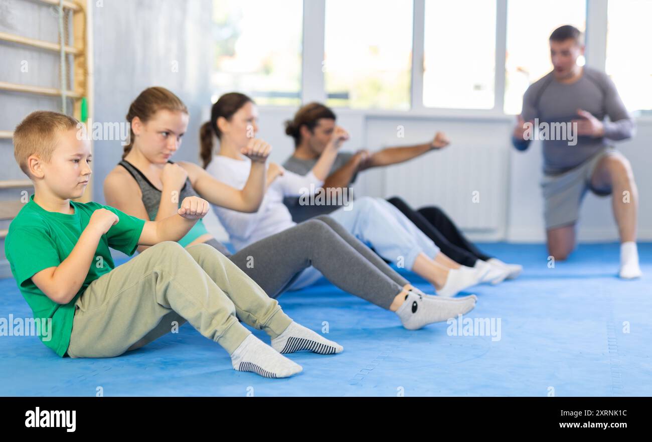 Family pupils performs exercises to strengthen press and improve ...