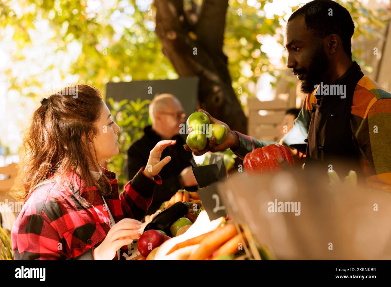 Man vendor standing behind a stall selling fresh organic fruits to ...