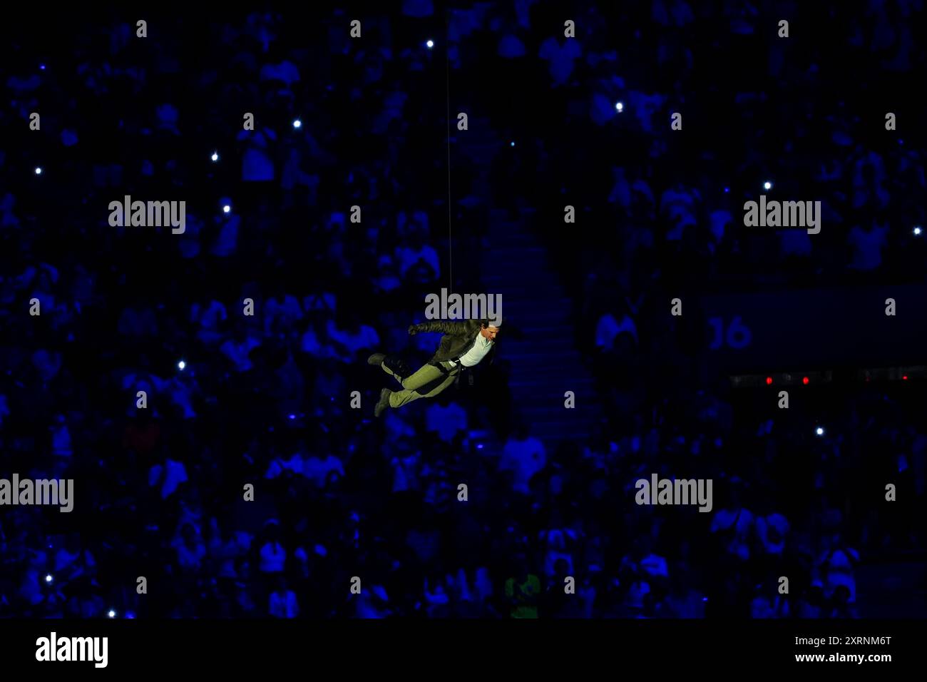 Tom Cruise descends into the stadium during the closing ceremony of the ...