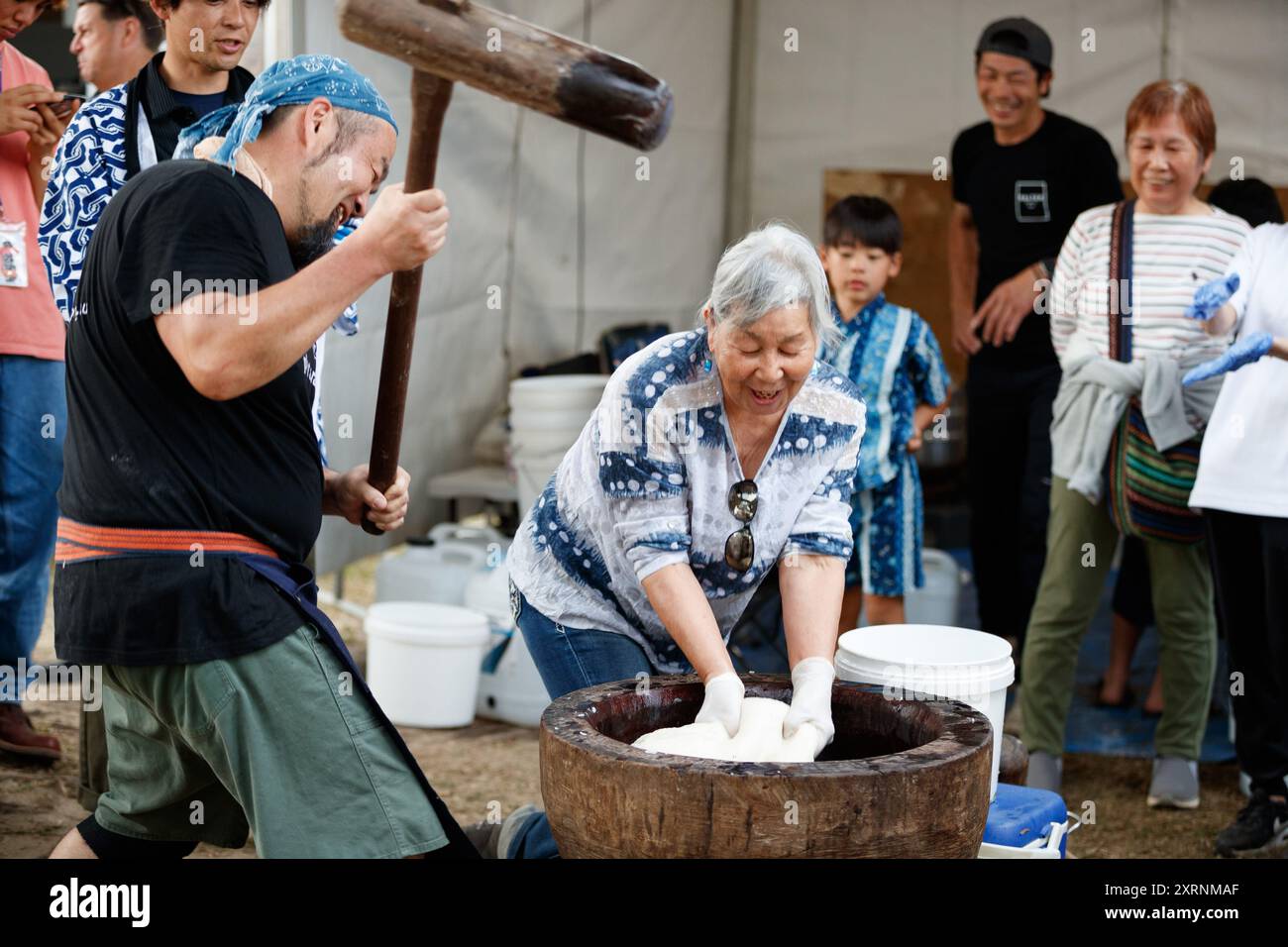 Cairns, Australia. 10th Aug, 2024. Crowd members join to mash rice in a ...