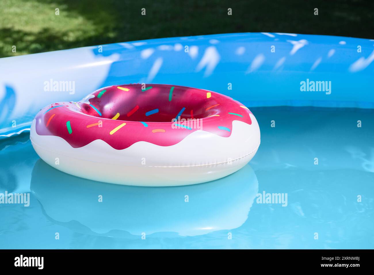 Inflatable swimming ring donut in an inflatable pool with blue water ...