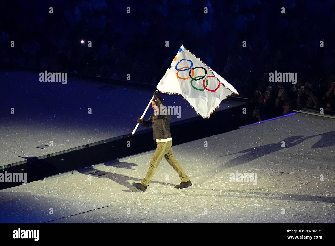 Tom Cruise leaves the stadium with the IOC flag during the closing ...