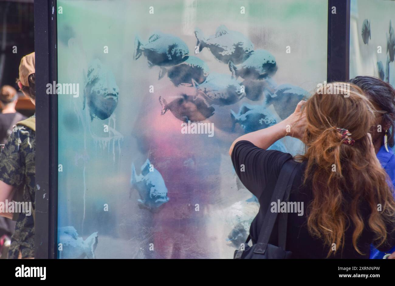 London, UK. 11th August 2024. A woman takes photos of the police sentry ...