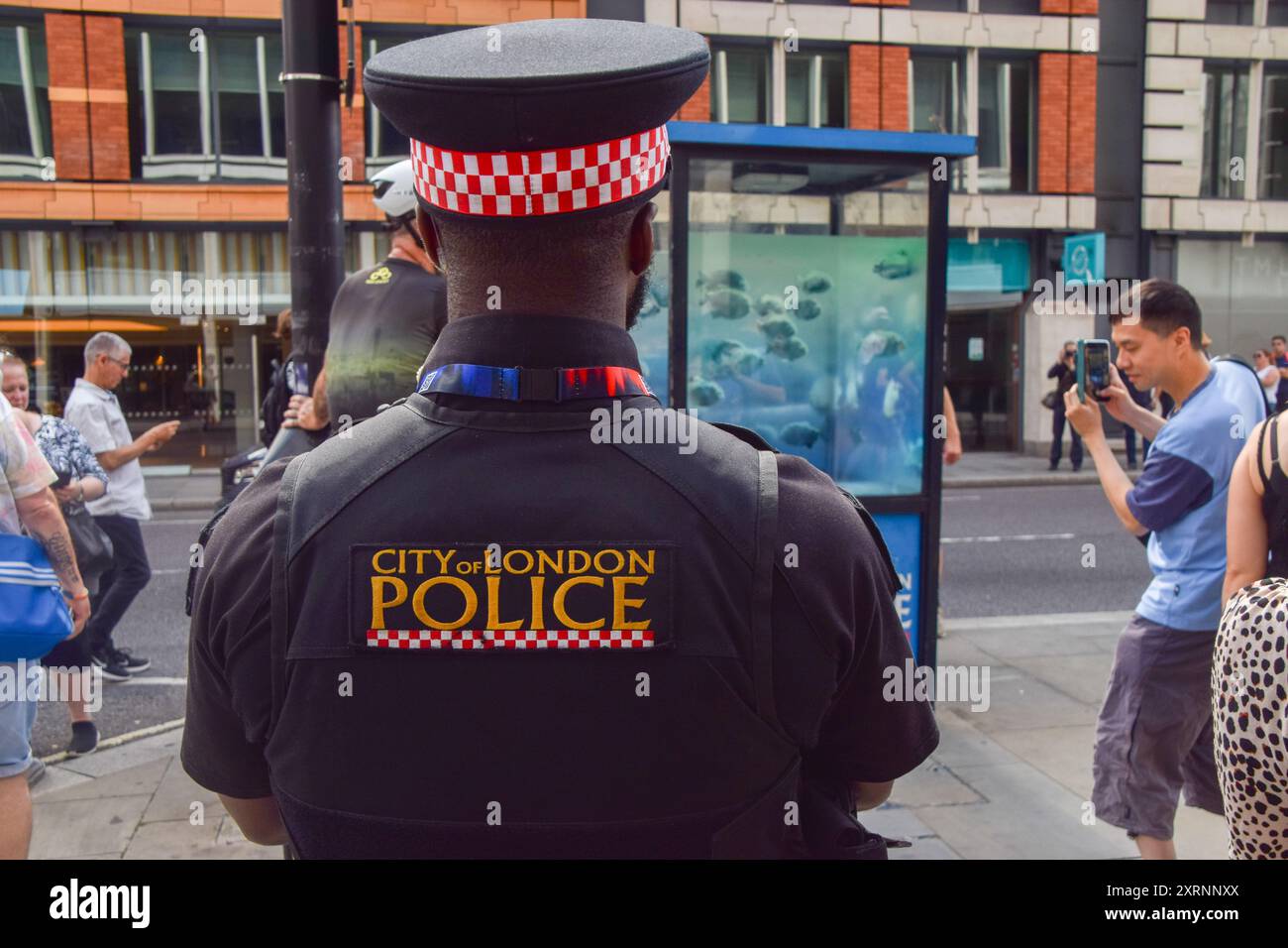 London, UK. 11th August 2024. A police officer observes people ...