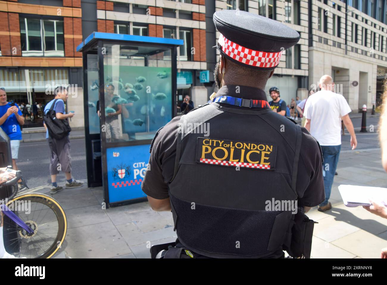 London, UK. 11th August 2024. A police officer observes people ...