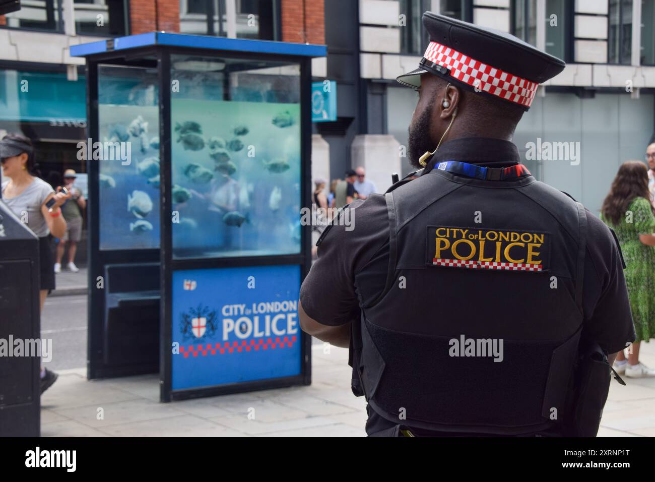London, UK. 11th August 2024. A police officer observes people ...