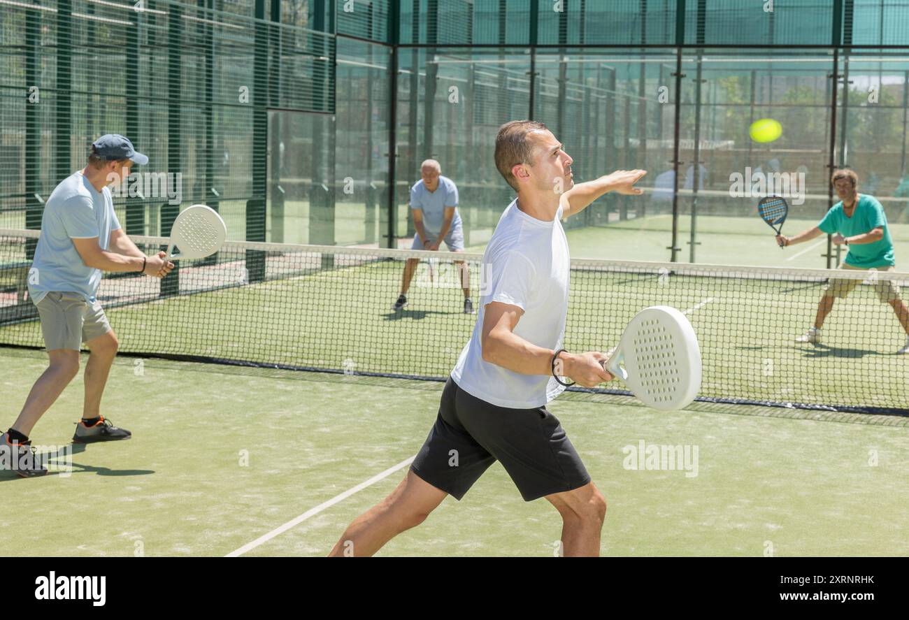 Padel game - man with partners plays on court Stock Photo - Alamy
