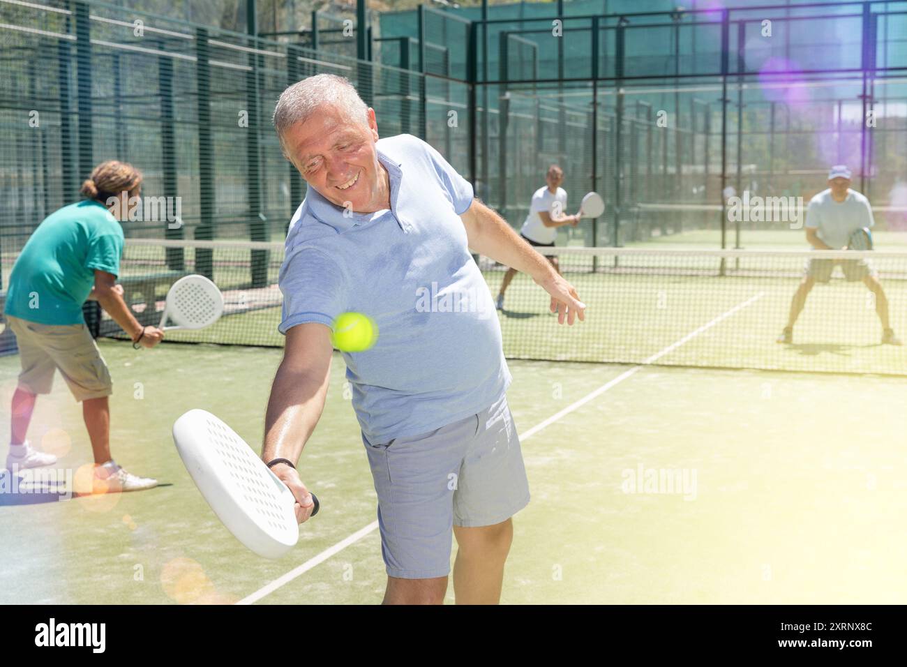 Adult and elderly men playing padel against two men Stock Photo - Alamy
