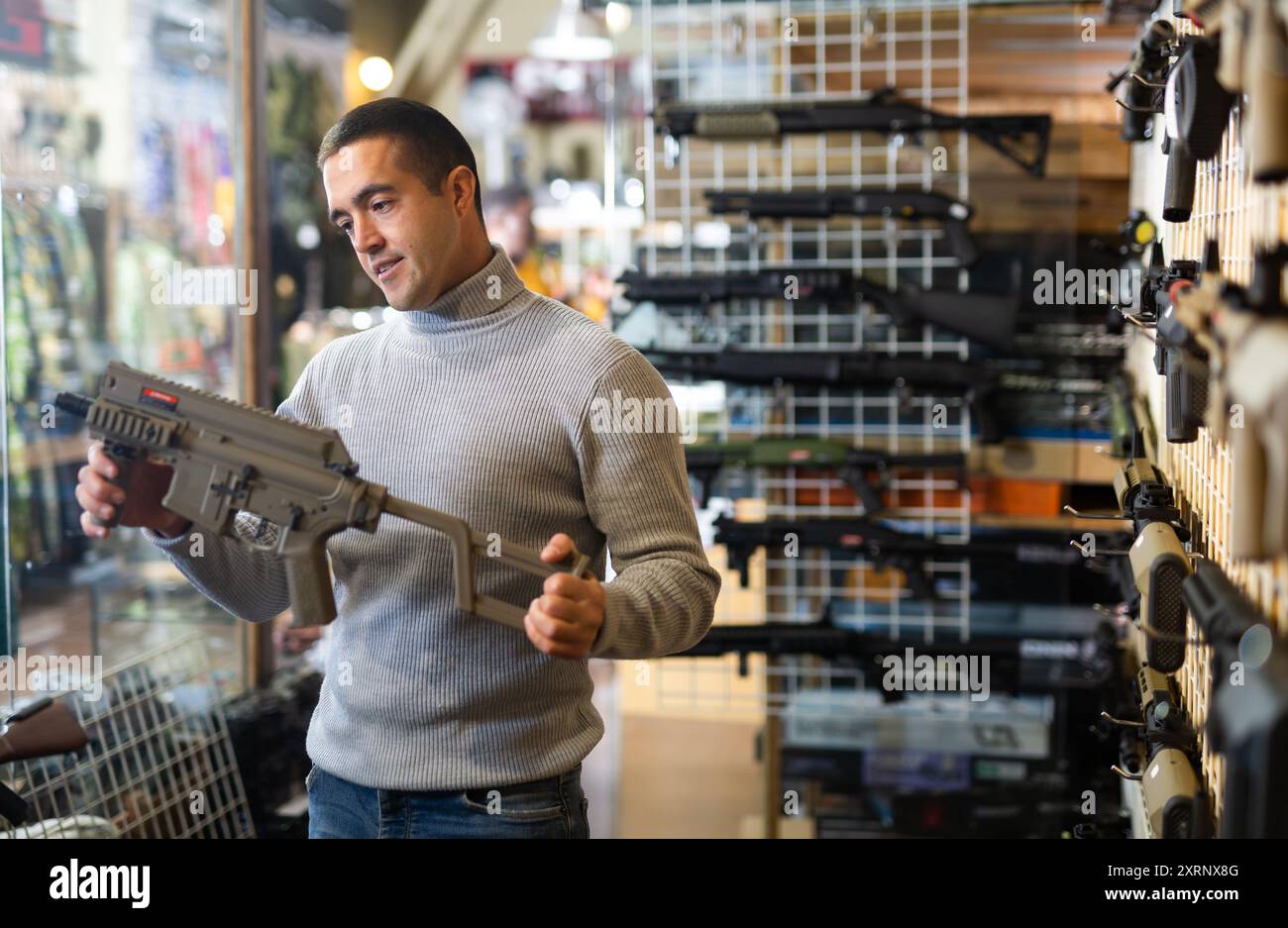 Man chooses semi-automatic pneumatic assault rifle at gun store Stock ...