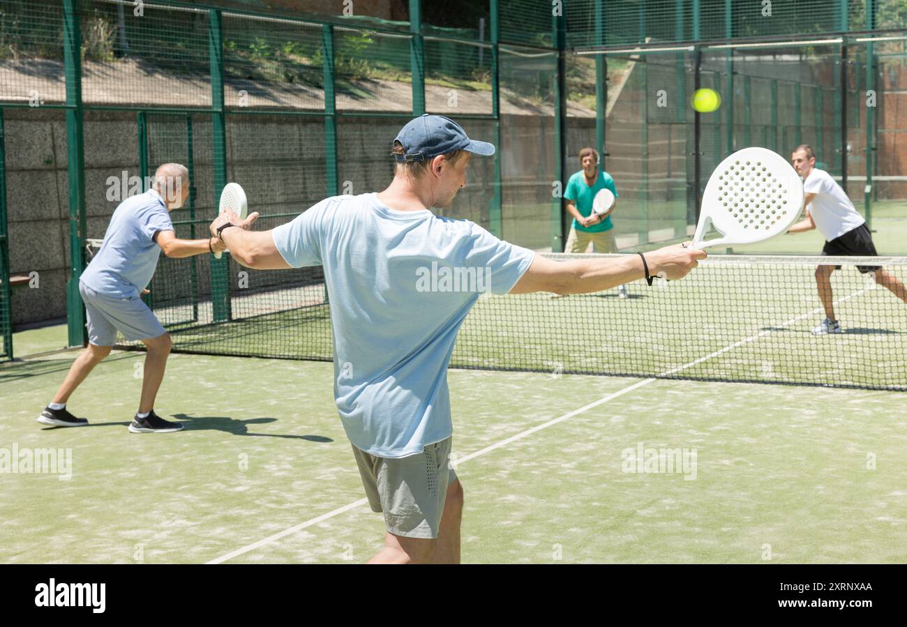 Adult and elderly men playing padel against two men Stock Photo - Alamy