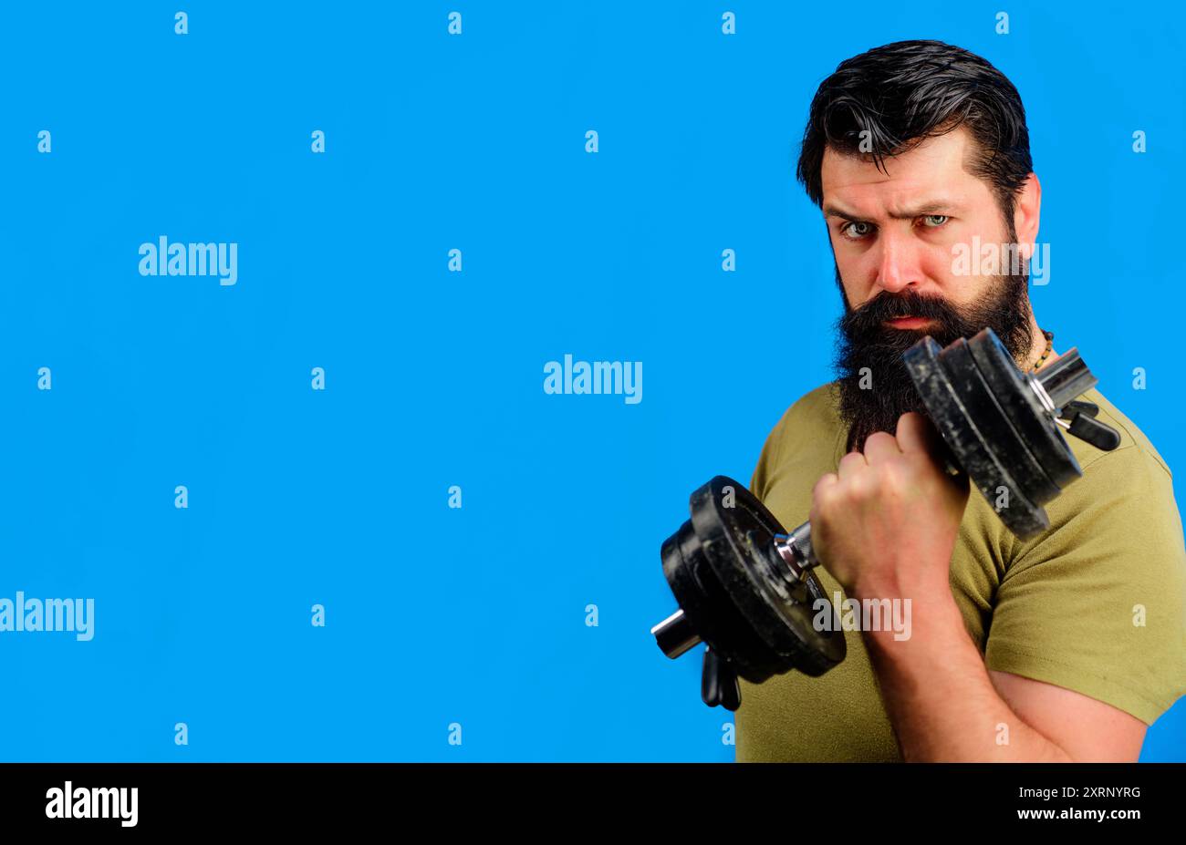 Serious man in sportswear raising dumbbell. Handsome male fitness model ...