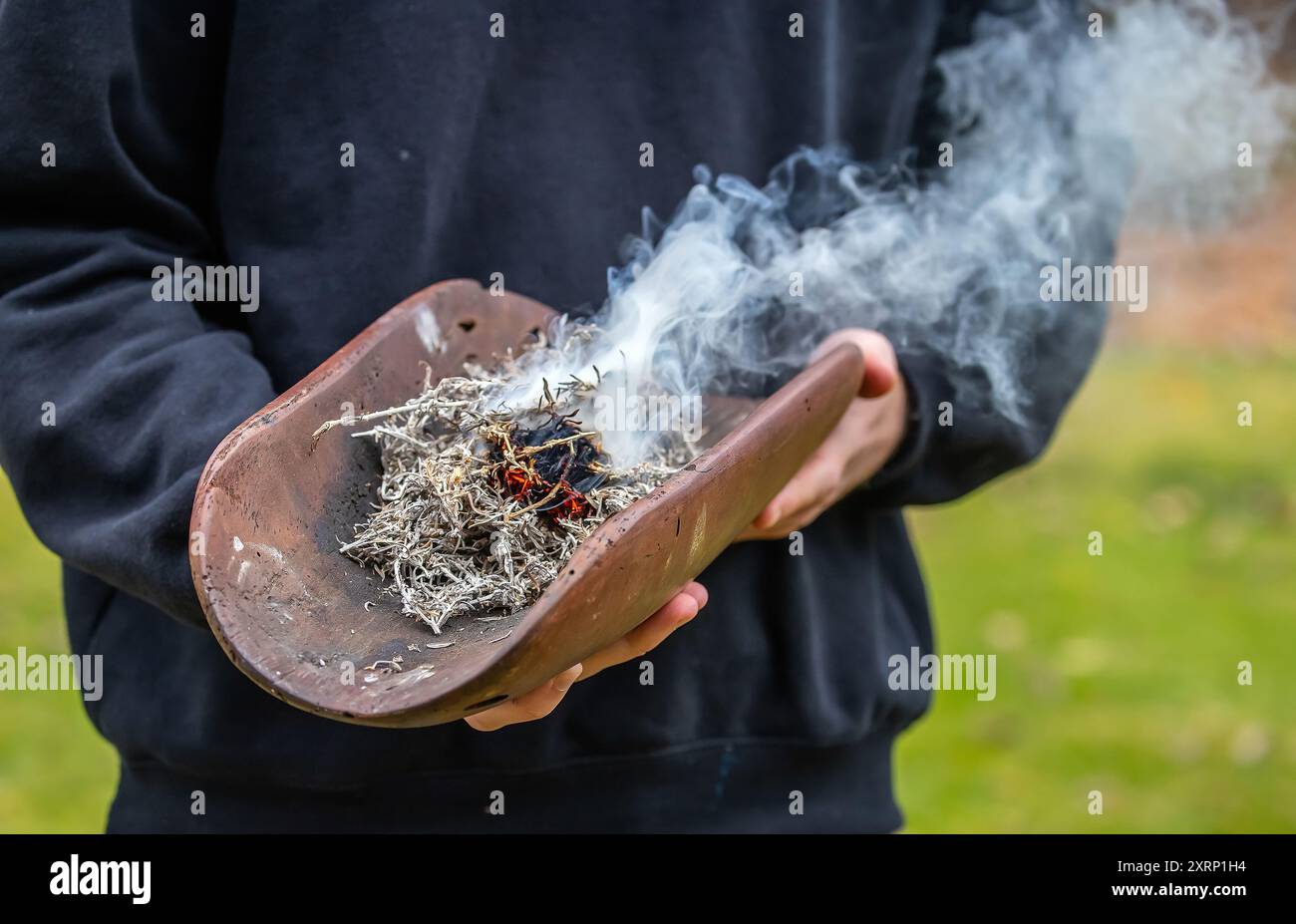 Human hands with wooden ritual dish and fire, Australian aboriginal ...