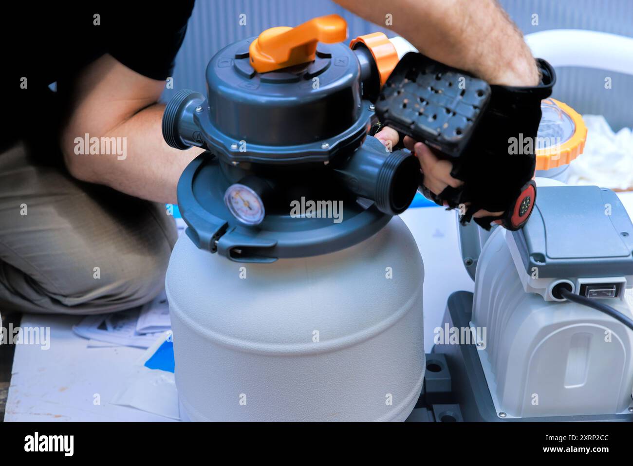 Maintenance worker service assembles sand filter system tank, equipment ...