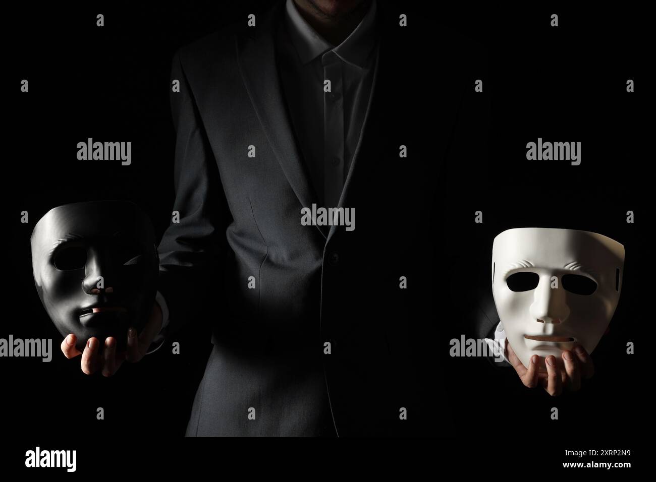 Theatrical performance. Man holding plastic masks on black background ...