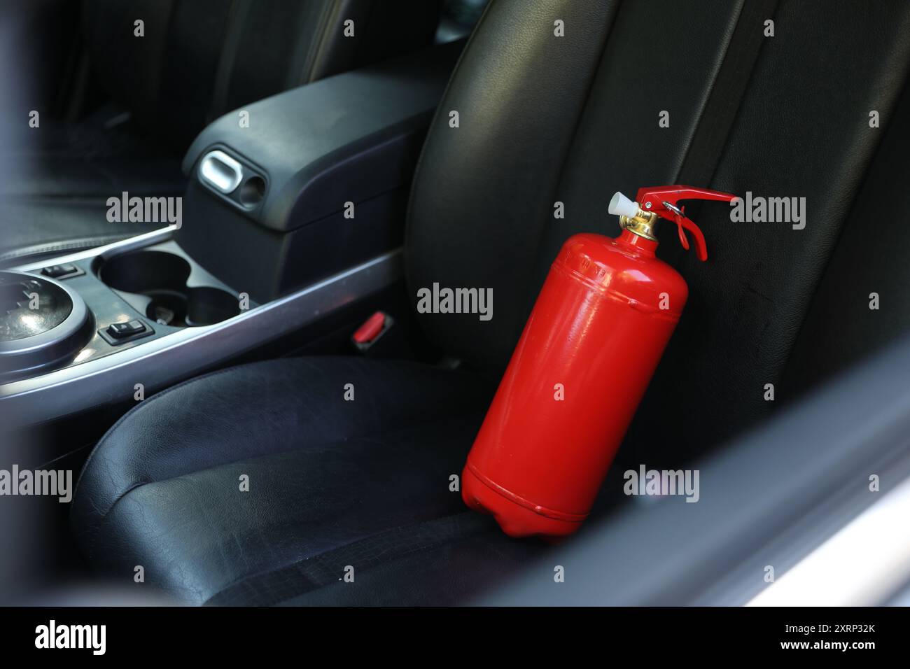 Red fire extinguisher in automobile. Car safety equipment Stock Photo ...