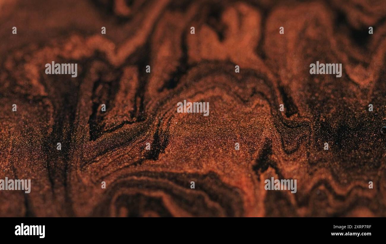 Ink glow flow. Brilliant paint texture bronze color liquid. Defocused ...