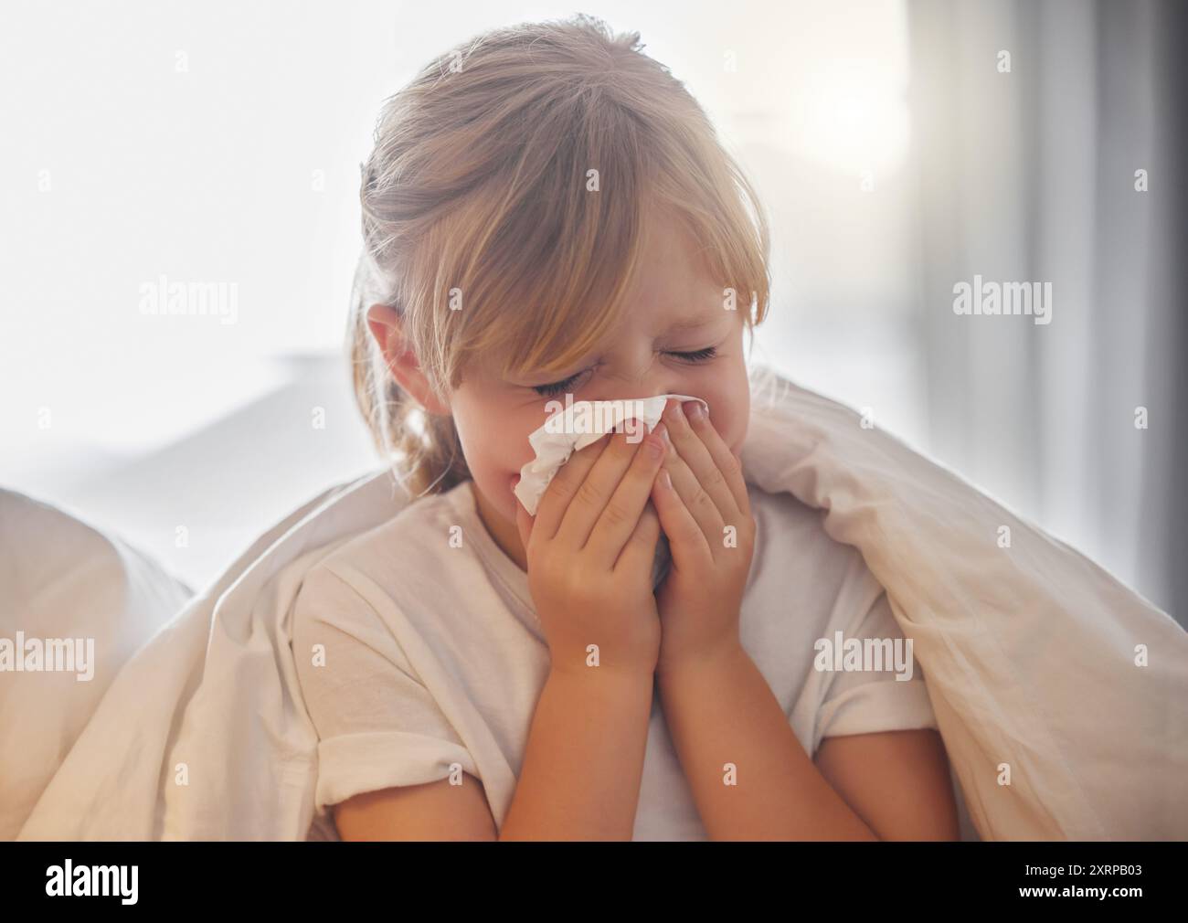 Child, sneezing and sick with tissue in bedroom for bacteria, sinusitis and viral infection. Kid ...