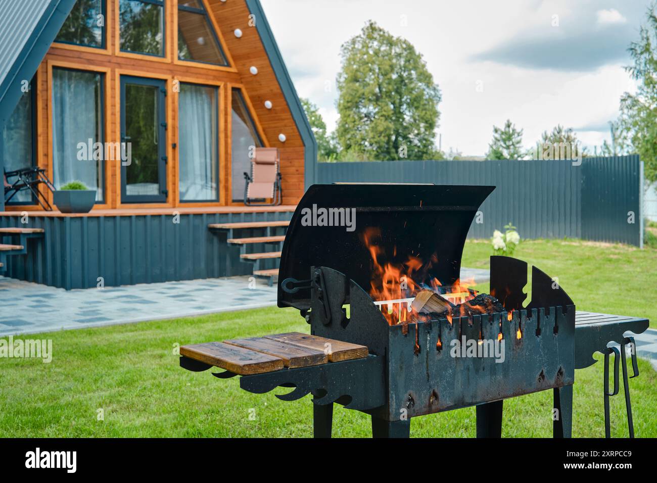 Brazier with burning wood on the background of a modern triangular ...