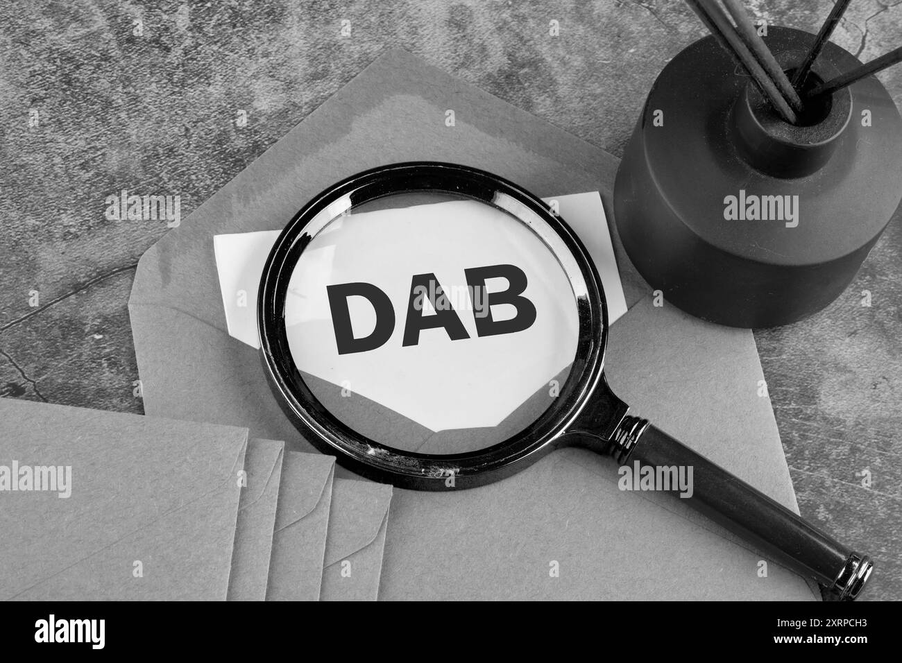 DAB Written appeared through a magnifying glass on a piece of paper ...
