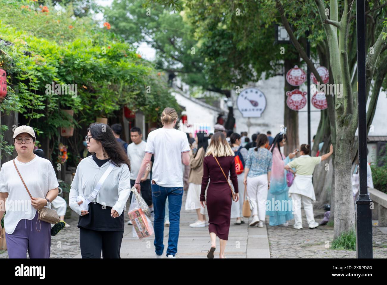 Suzhou, China - June 11, 2024 : People walk along a cobblestone pathway ...