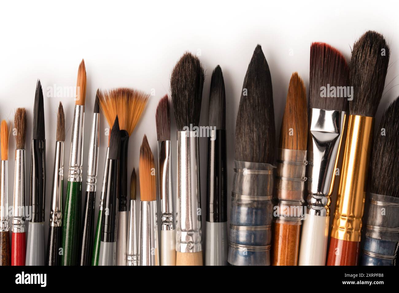 Mix of paint brushes in a row isolated on a white background. Top view ...