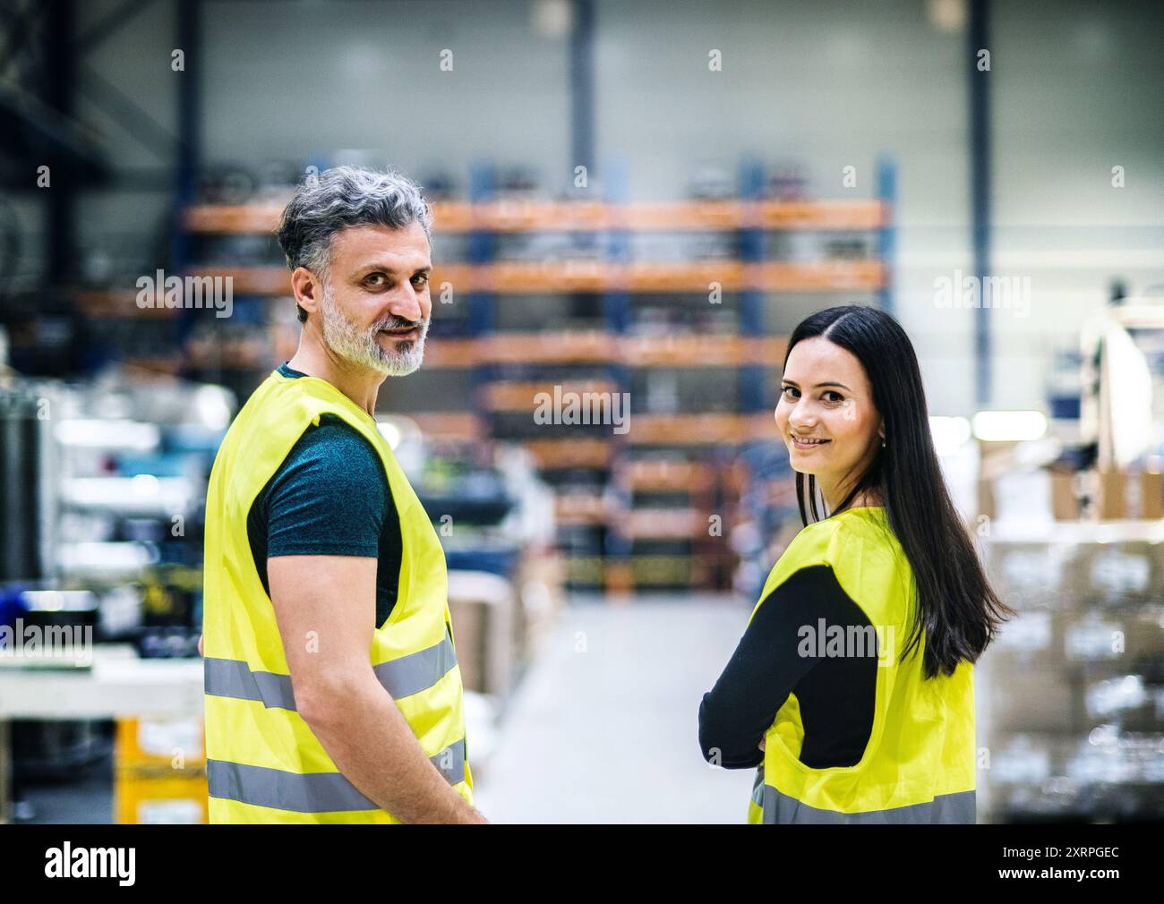 Warehouse employees in warehouse. Two workers in reflective clothing in ...